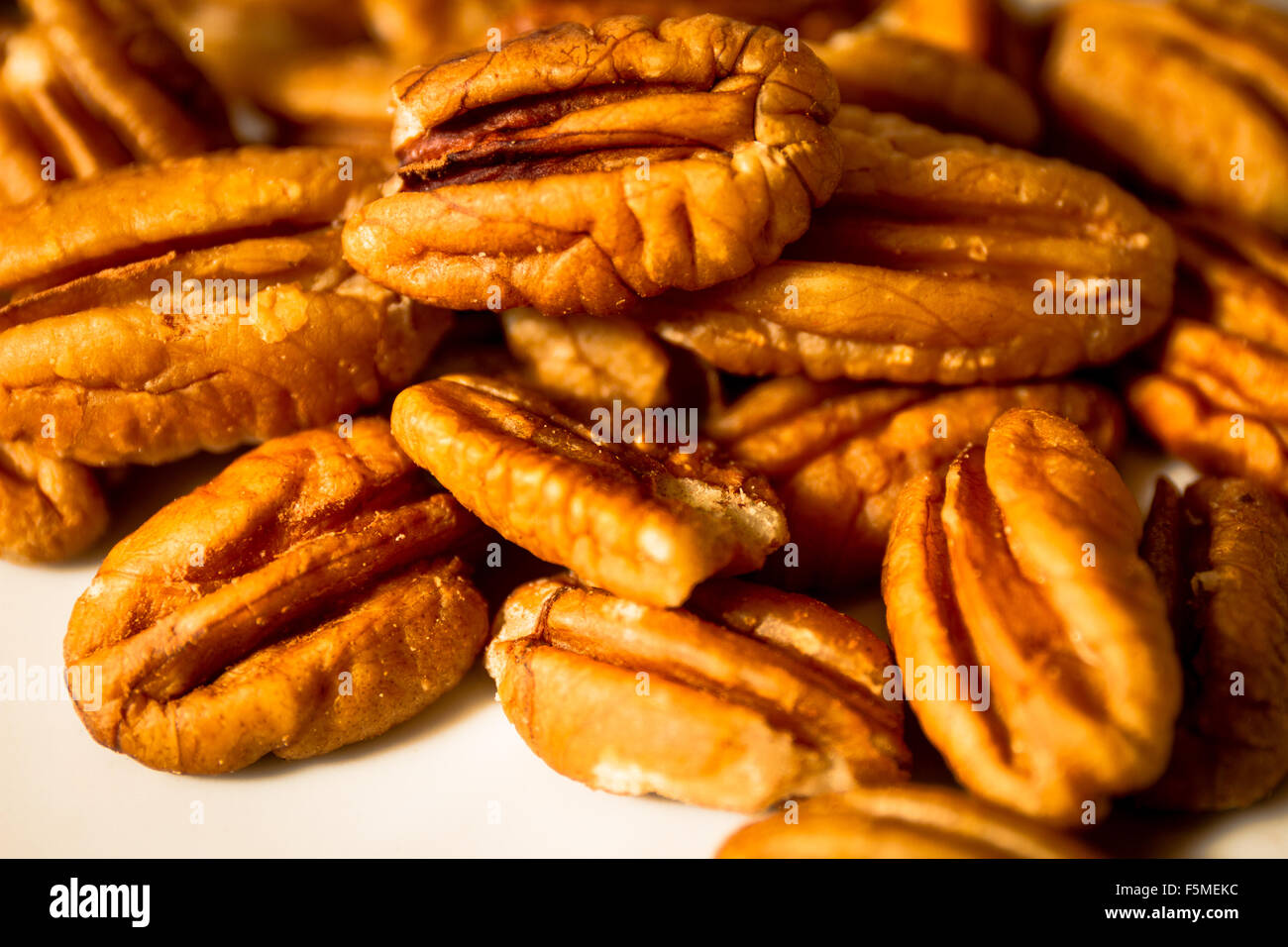 A close-up shot of a pile of pecans of various size on a white serving ...