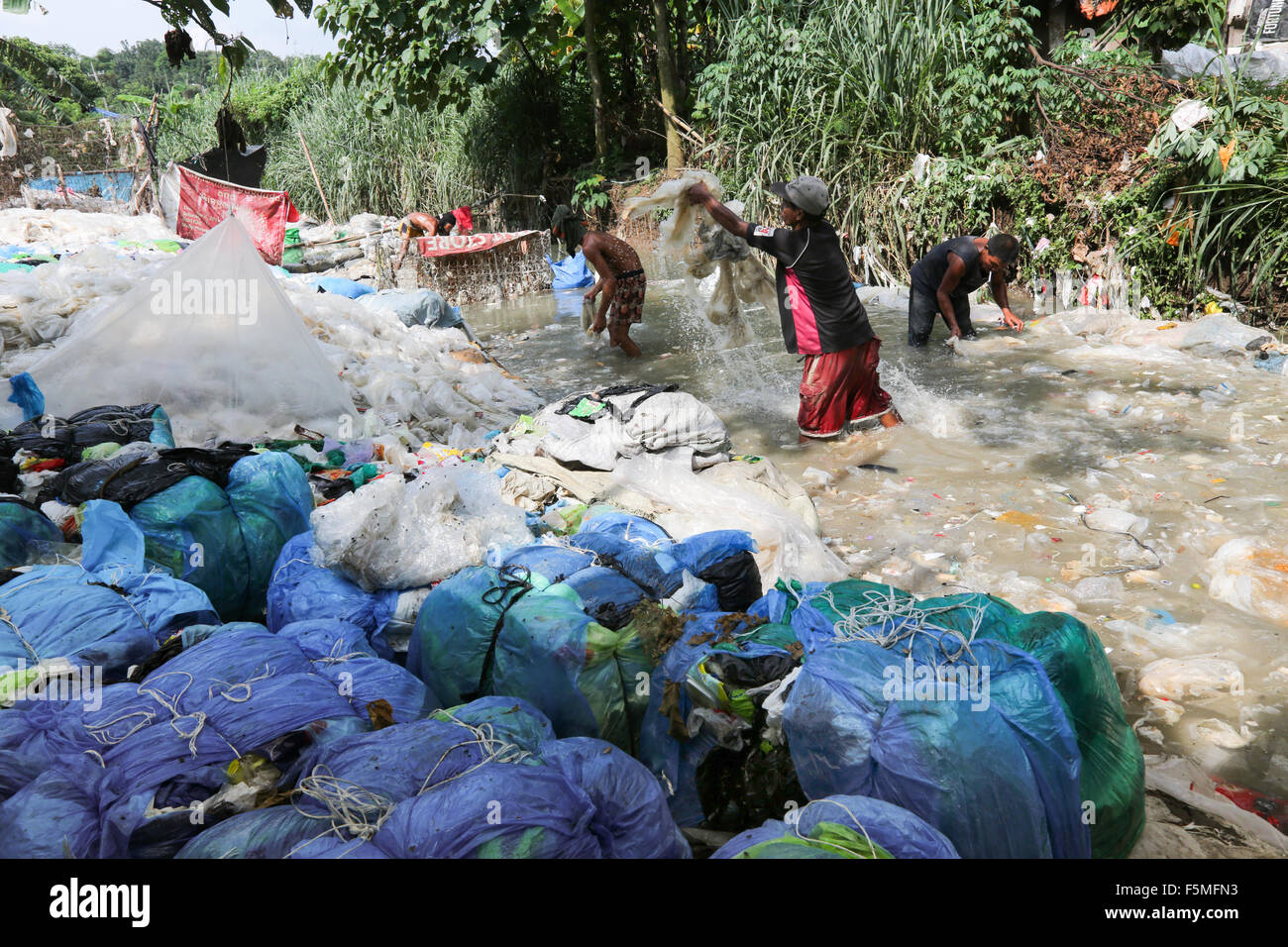 Garbage collectors washing plastic sheets in a stream to supply them to ...