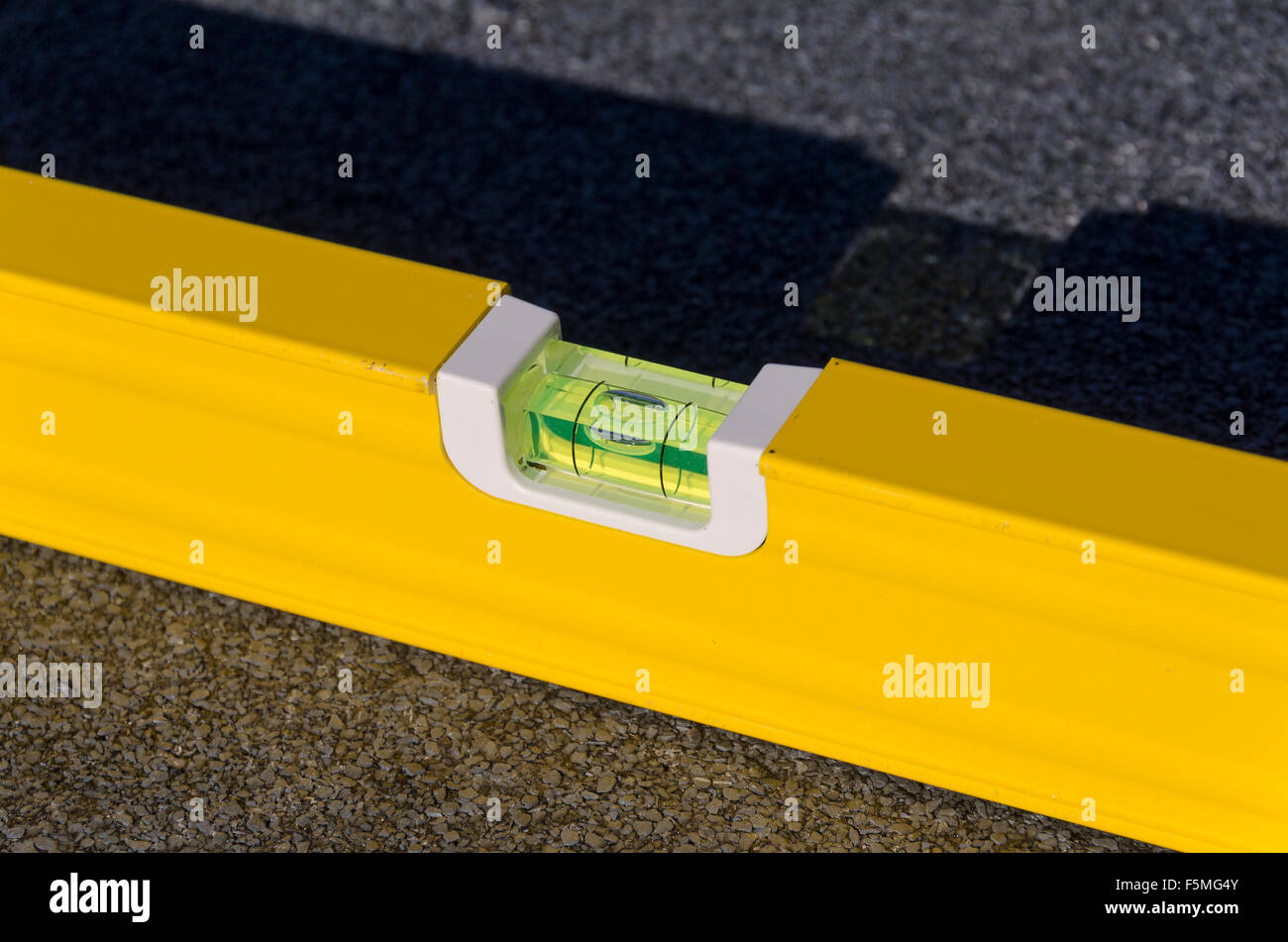 Yellow spirit level on a roof Stock Photo - Alamy