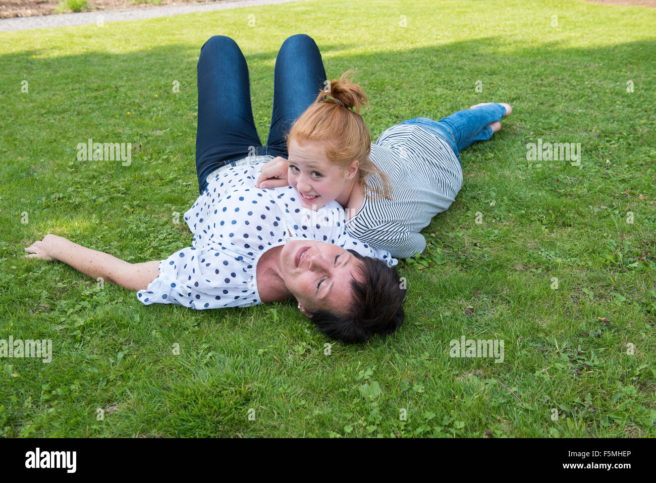 mother and girl on the grass, girls head on mothers chest Stock Photo ...