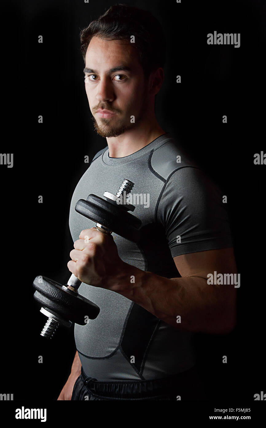 Athletic man lifting dumbell Stock Photo - Alamy