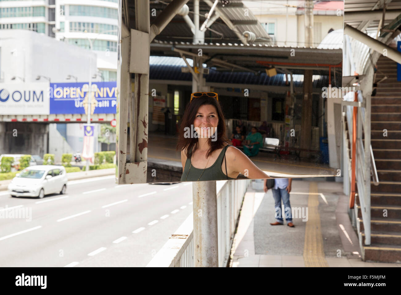 A woman poses in a mirror on a train platform in Kuala Lumpur Stock ...