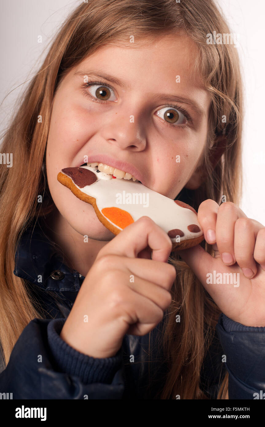 Girl with tasty cookie, she eats it with passion Stock Photo - Alamy