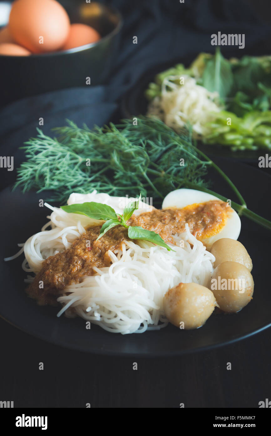 Thai rice vermicelli "Knom-jean" with curry on black wood table Stock ...