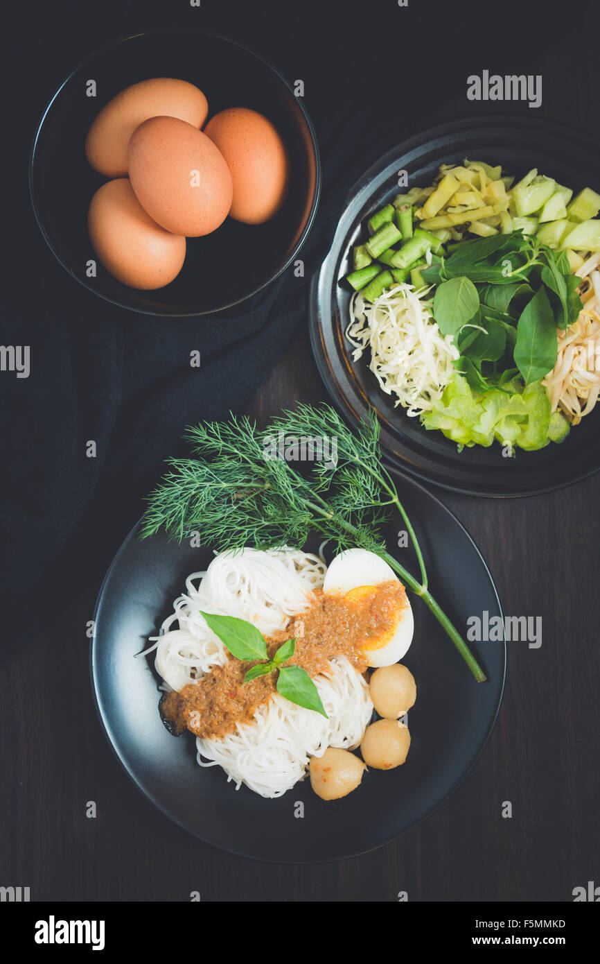 Thai rice vermicelli "Knom-jean" with curry on black wood table Stock ...