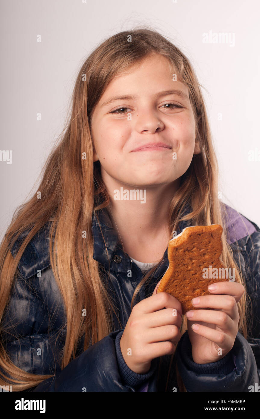 Girl with cookie portrait, she likes it very much Stock Photo - Alamy