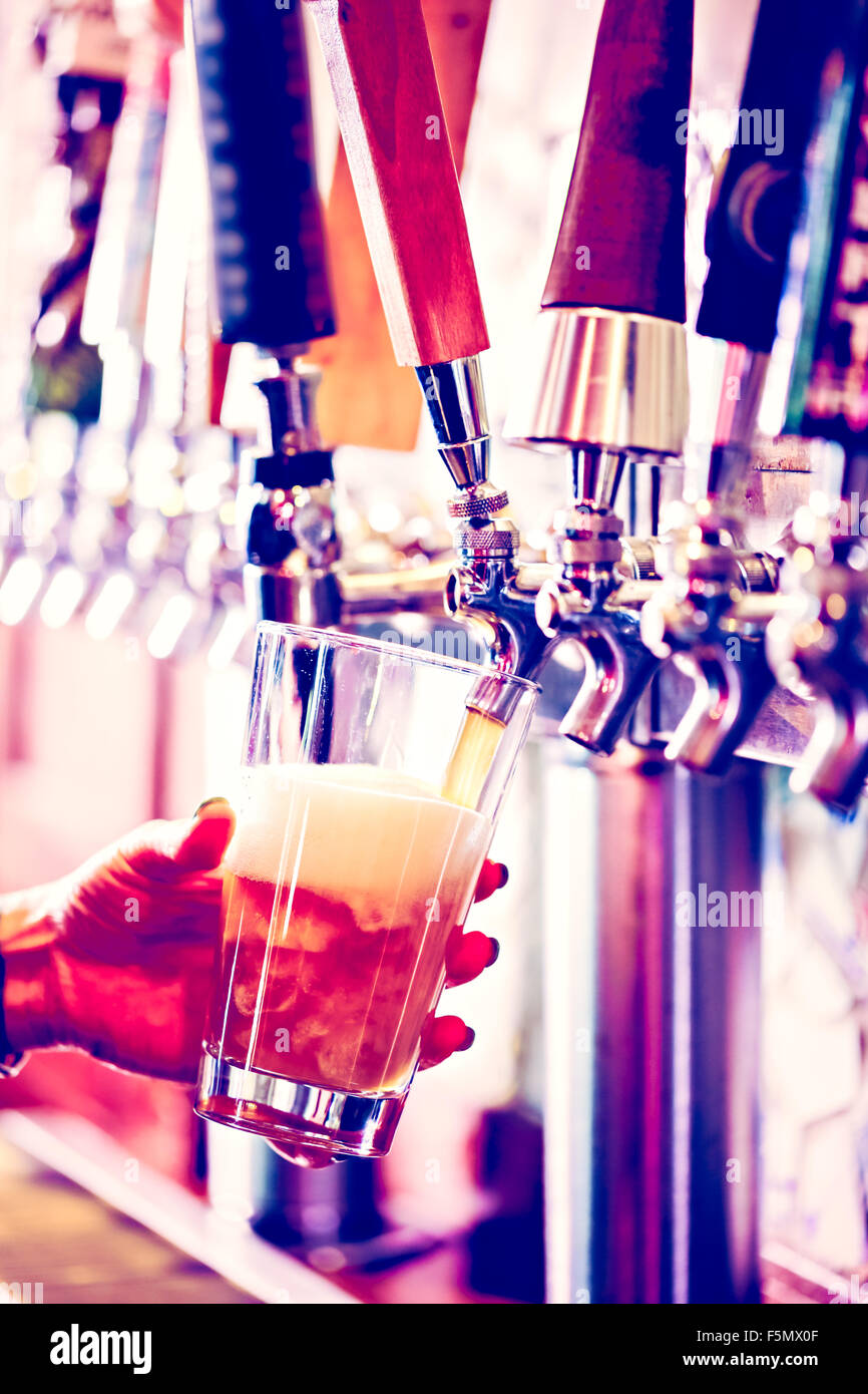 Bartender pouring draft beer in the bar Stock Photo - Alamy