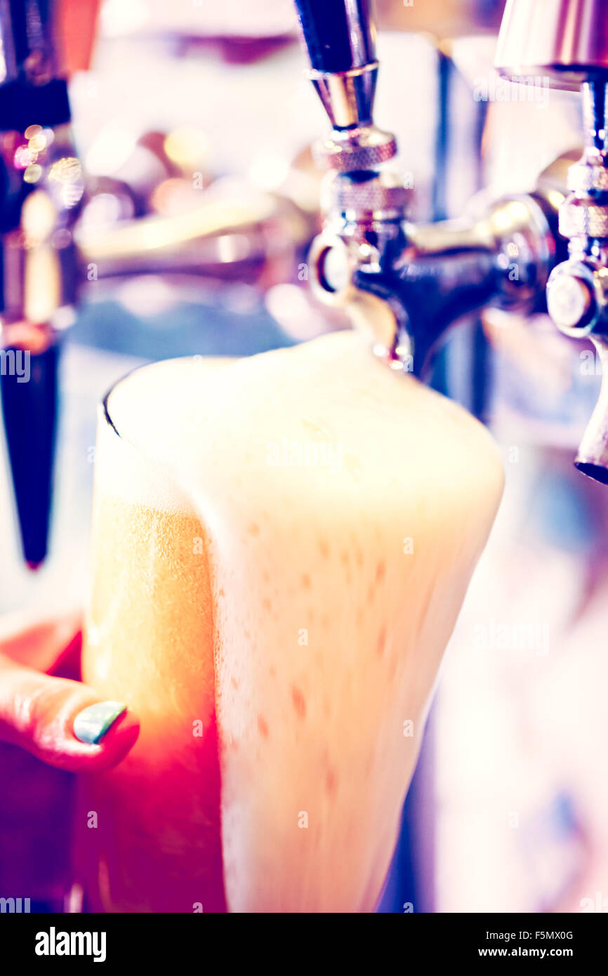 Bartender pouring draft beer in the bar Stock Photo - Alamy