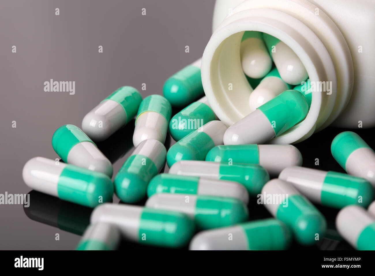 Pills spilling from an open bottle Stock Photo - Alamy