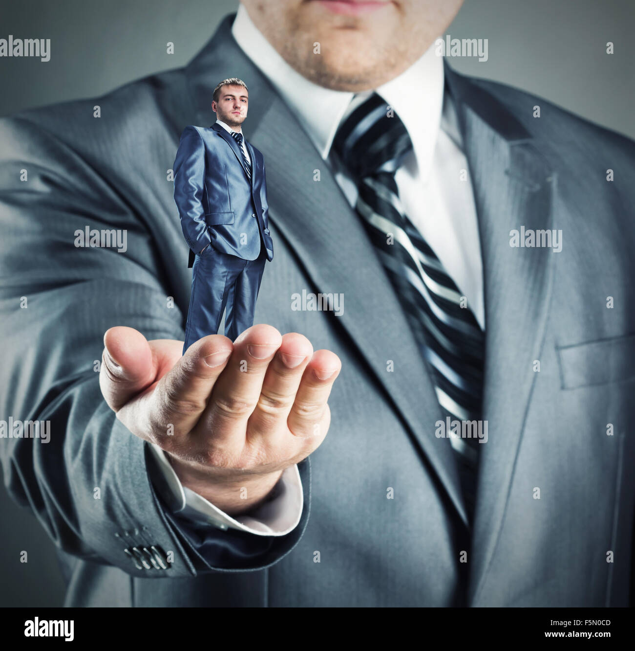 Hand giving small confident businessman Stock Photo - Alamy
