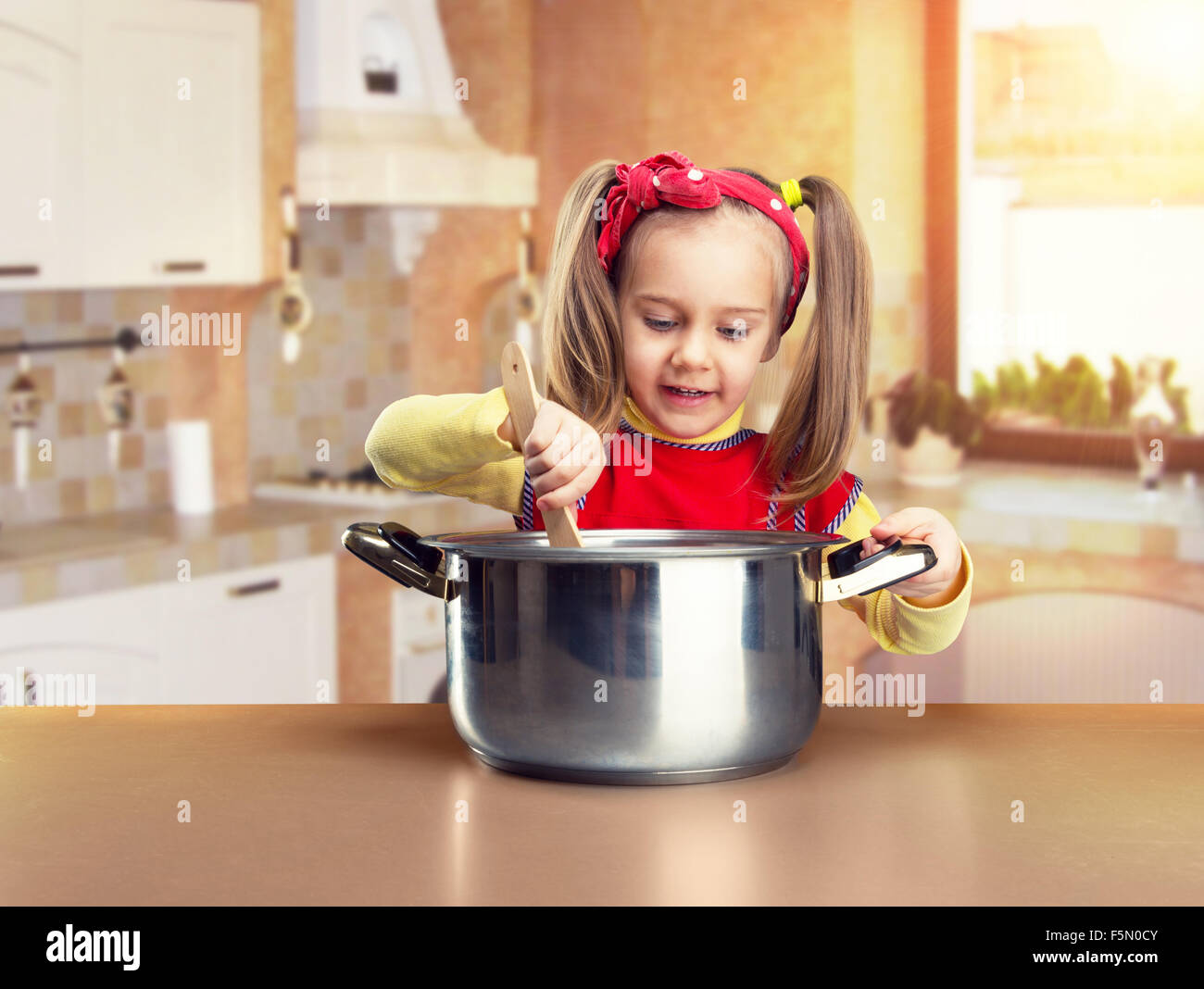 Cute little girl cooking at home Stock Photo - Alamy