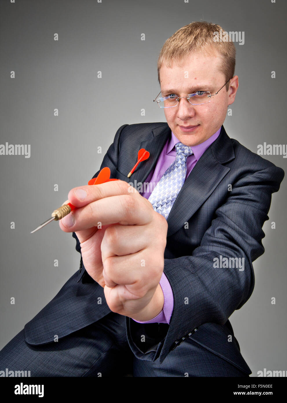 Portrait of serious businessman aiming by red dart Stock Photo - Alamy