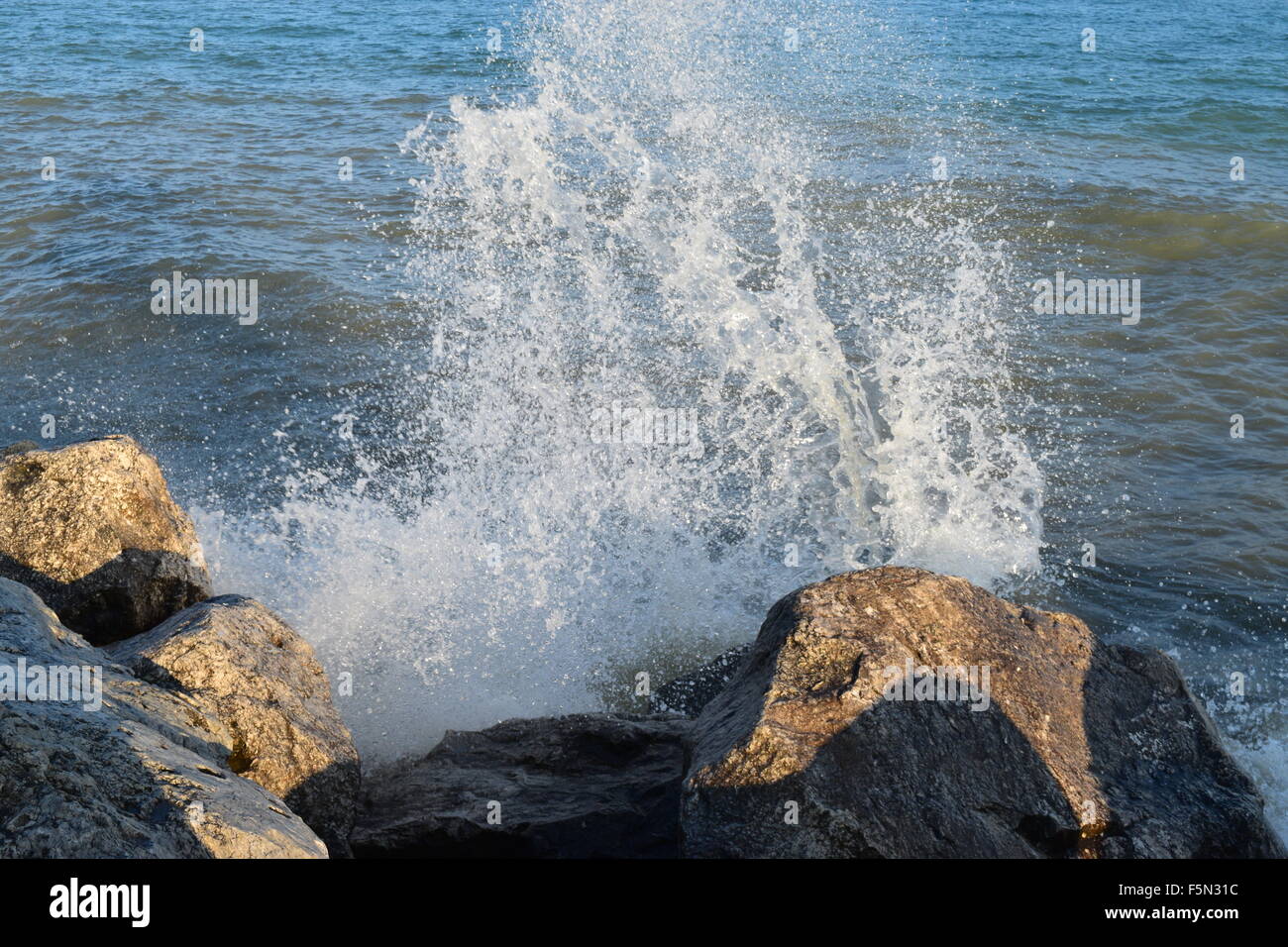 Splash of water on rocks Stock Photo - Alamy
