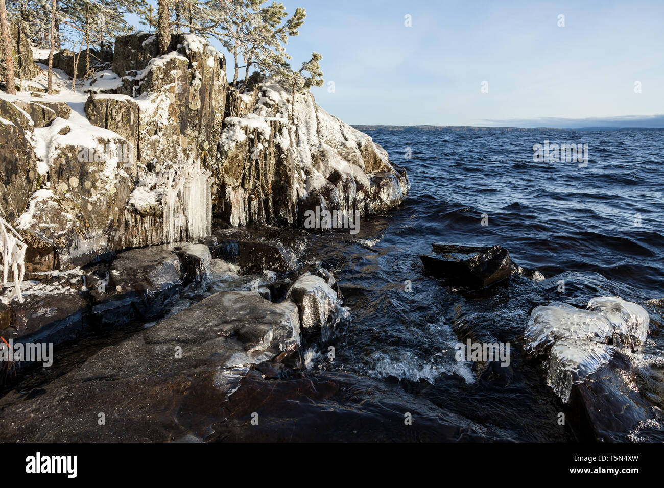 Frozen lakefront rock cliff Stock Photo - Alamy