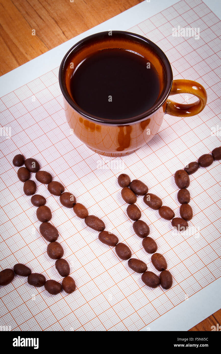 Electrocardiogram line of roasted coffee grains and cup of hot coffee ...