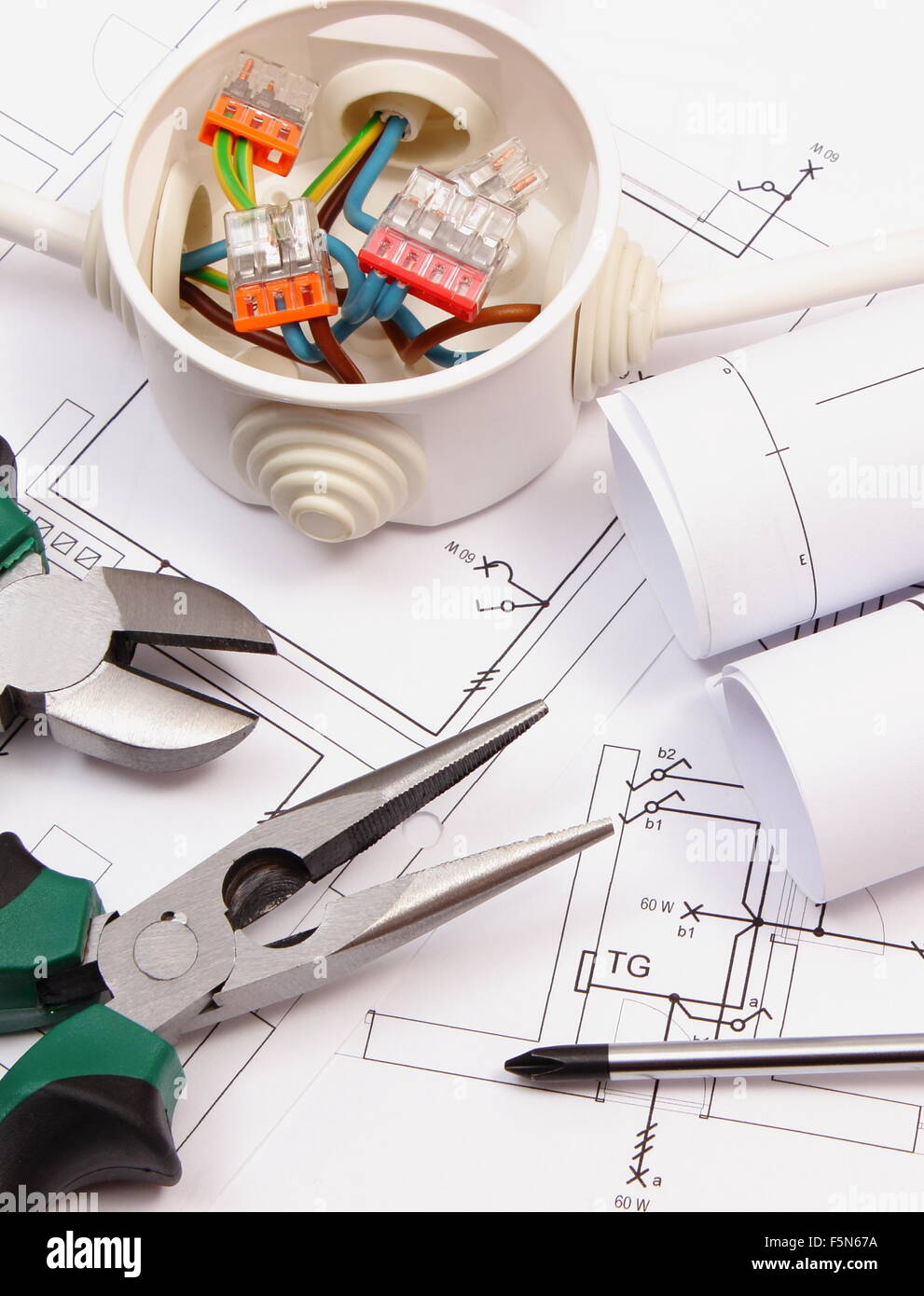 Work tools, rolls of diagrams and cable connections in electrical box ...