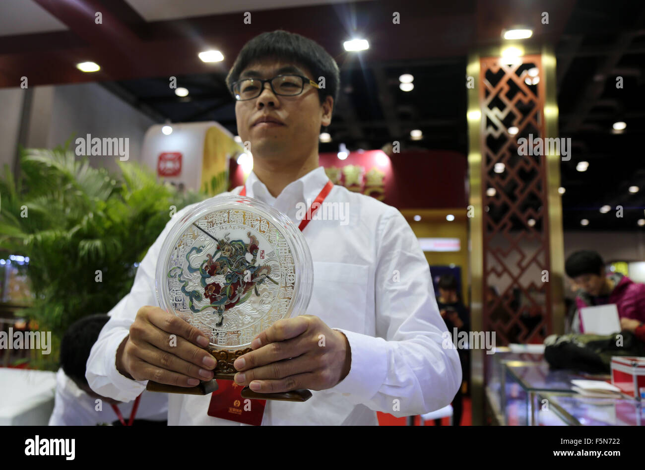 Beijing, China. 7th Nov, 2015. An exhibitor shows a silver badge during ...