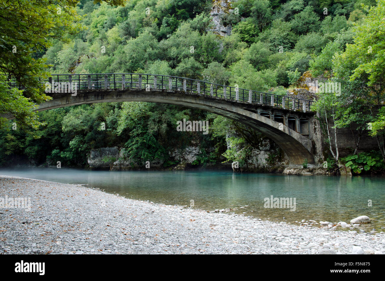 Old greece bridge over crystal clear blue water from the mountains not ...