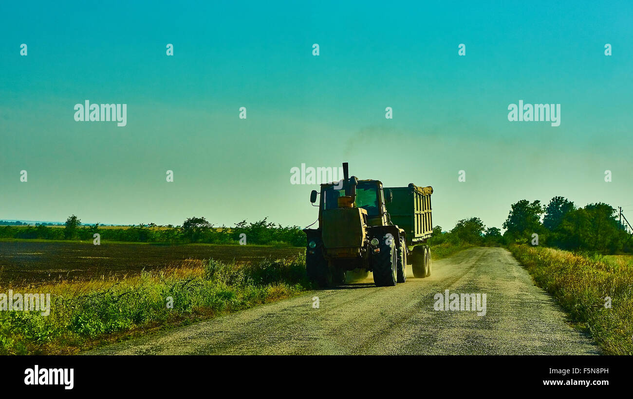 Tractor on the road with trailer at summer day Stock Photo - Alamy