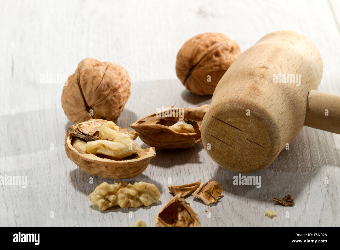 walnuts with a wooden hammer Stock Photo - Alamy
