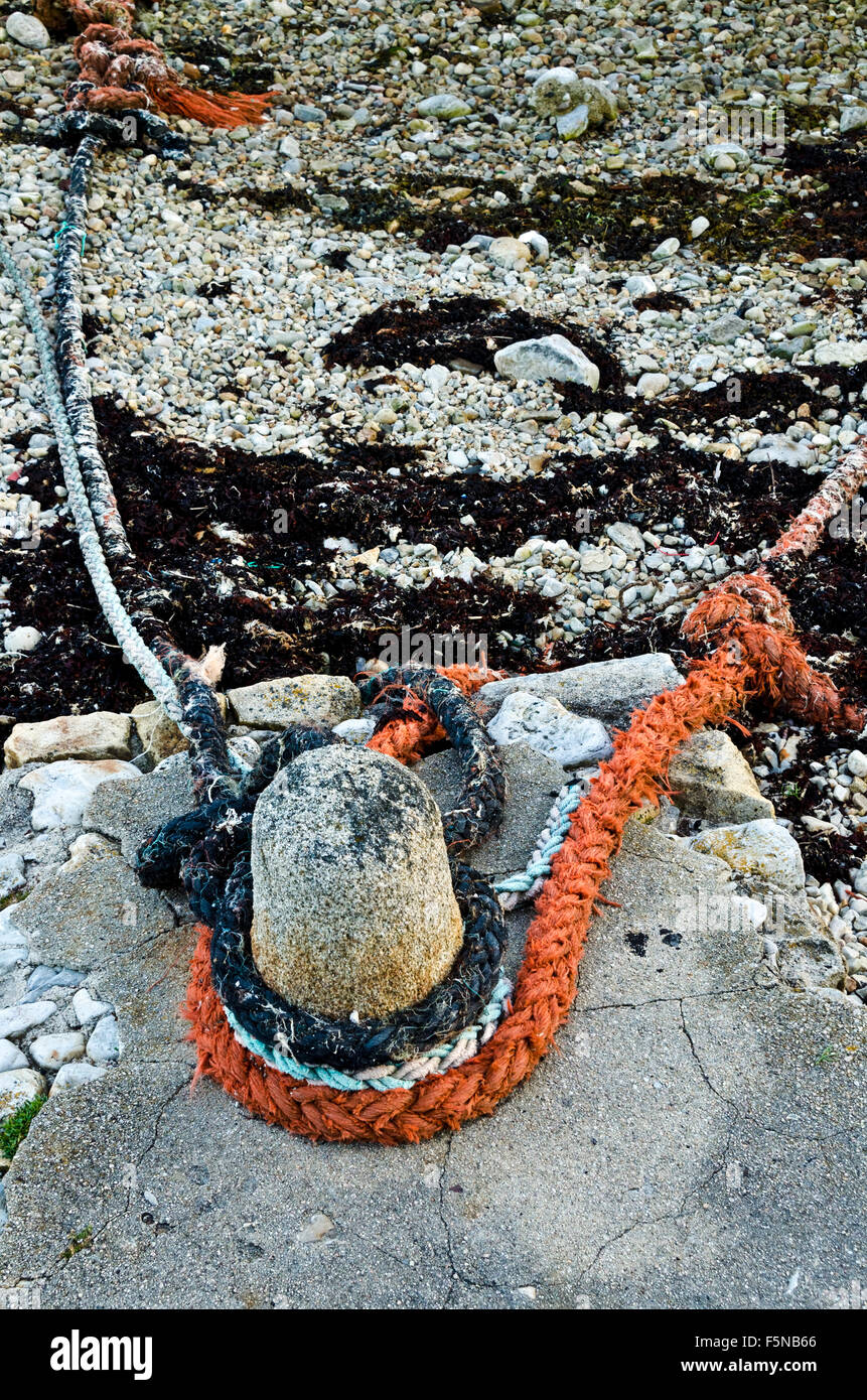 orange and white mooring ropes tethered around stone bollard Stock ...