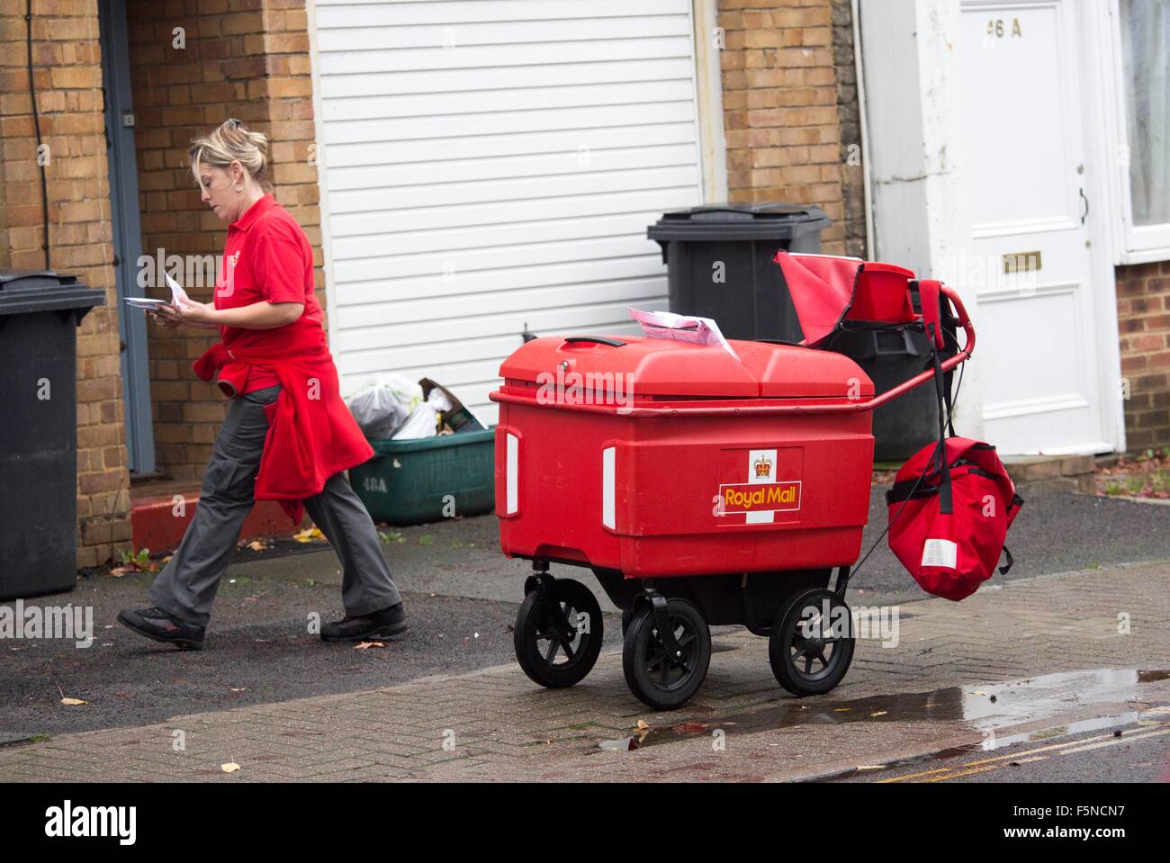 Postman postwoman post delivery trolly red letters Stock Photo - Alamy