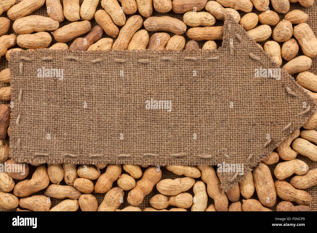 Arrow made of burlap lies on peanuts, with space for your text Stock ...