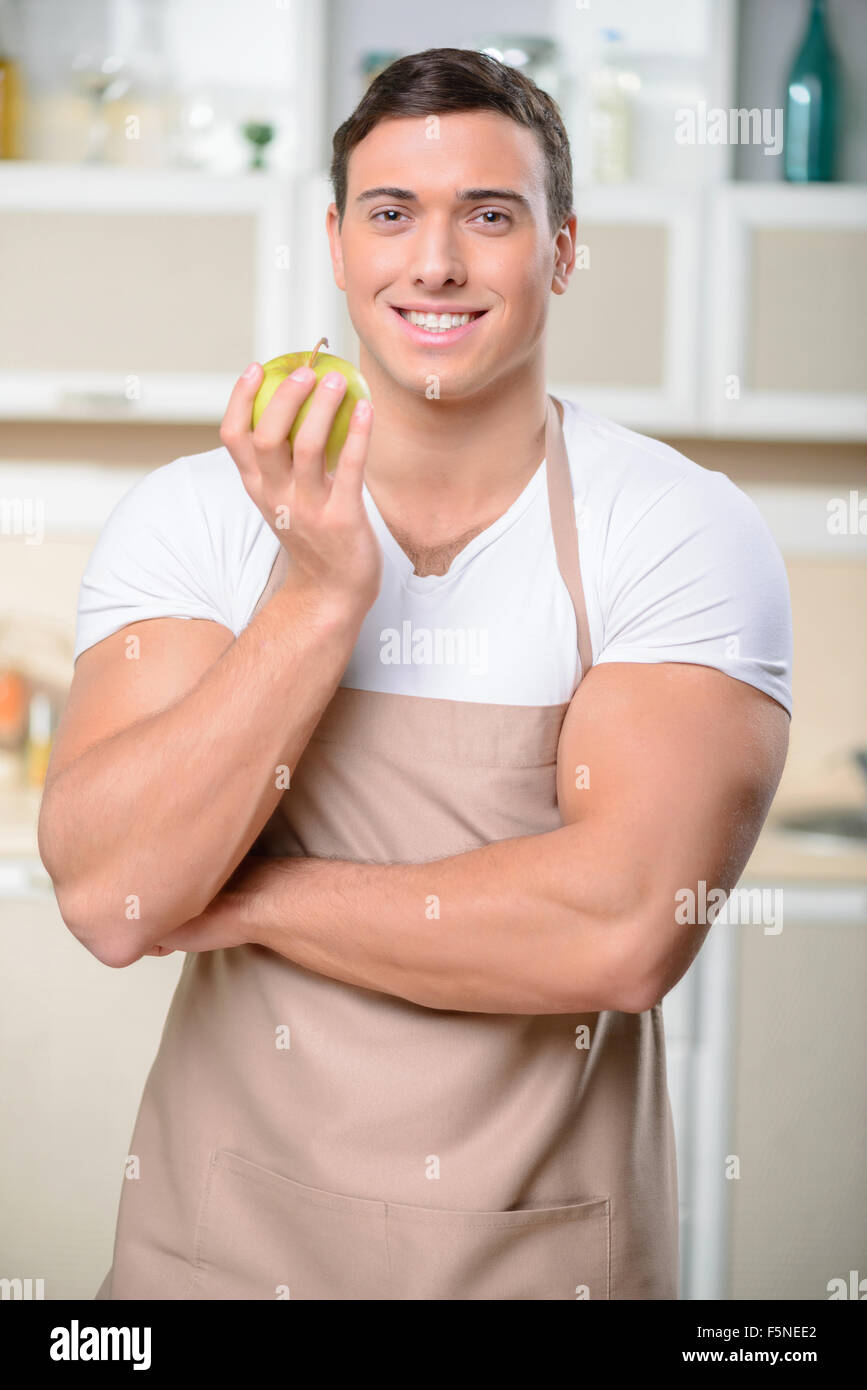 Smiling strong man holding an apple Stock Photo - Alamy