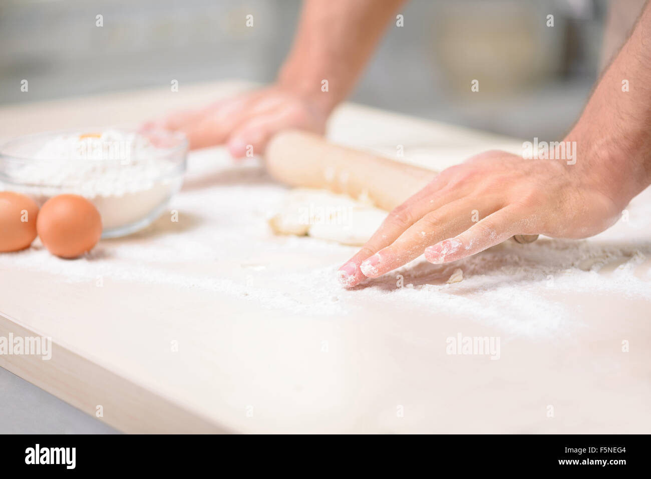 Young male cook is stretching the dough thoroughly Stock Photo - Alamy