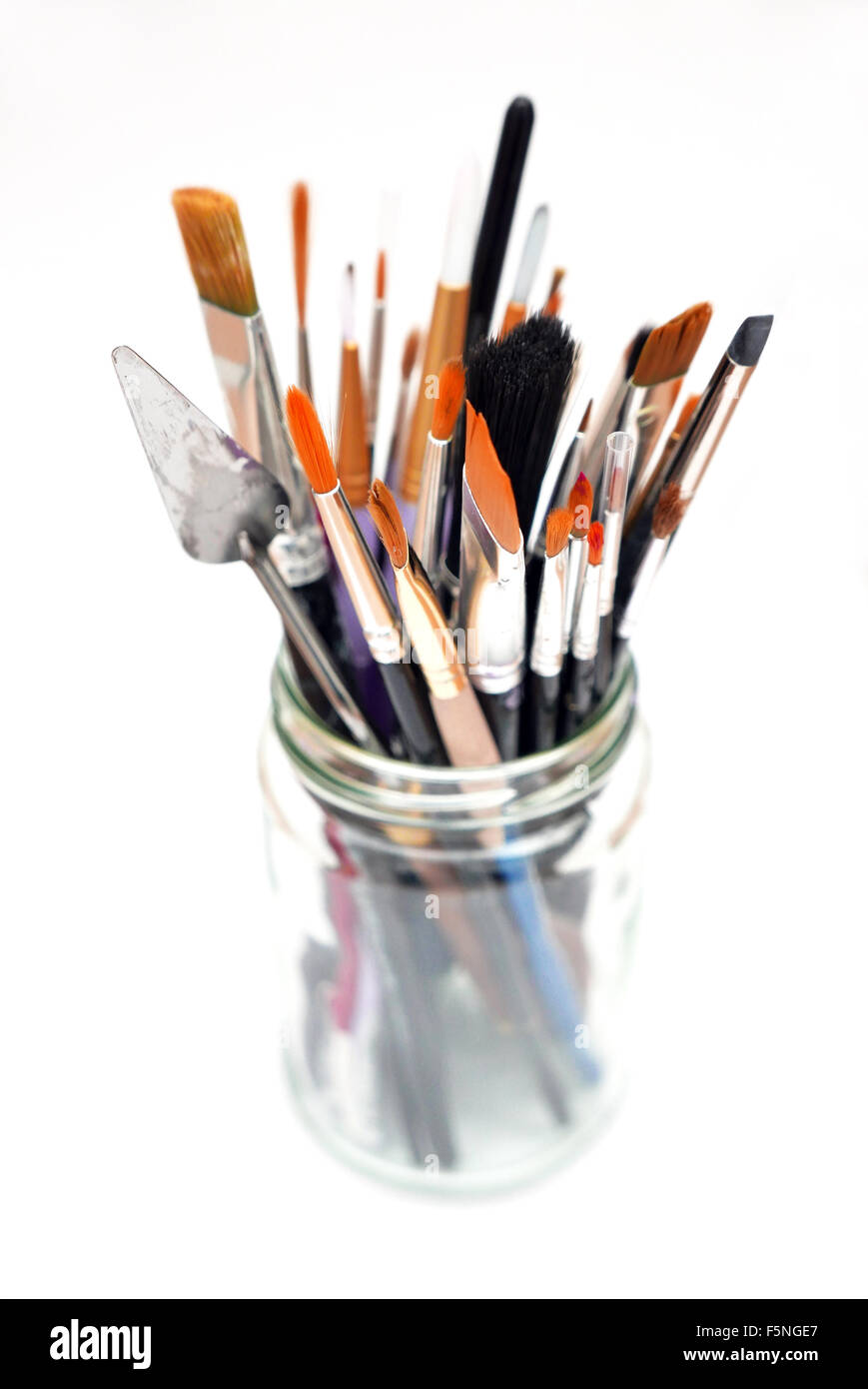 Craft making tools including brushes, palette knife in a jam jar on a ...
