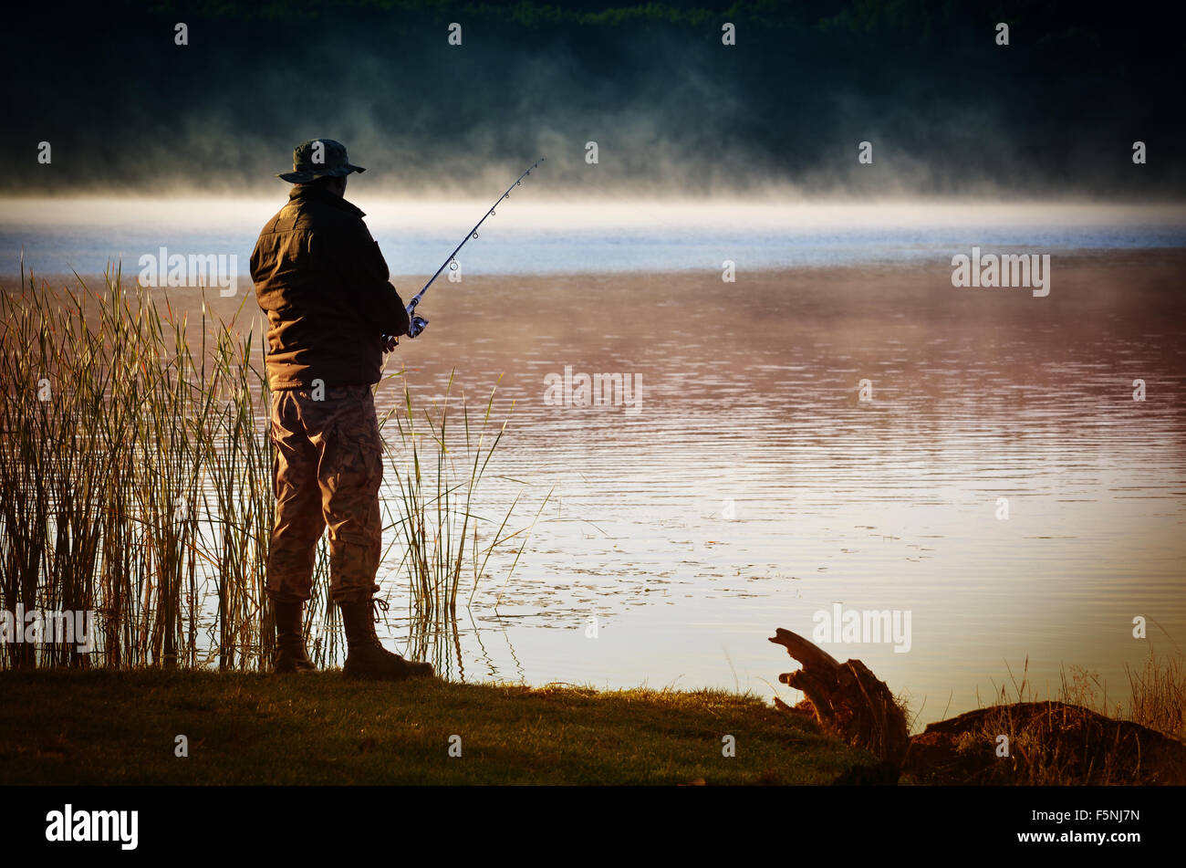 Lone fisherman catches fish Stock Photo - Alamy