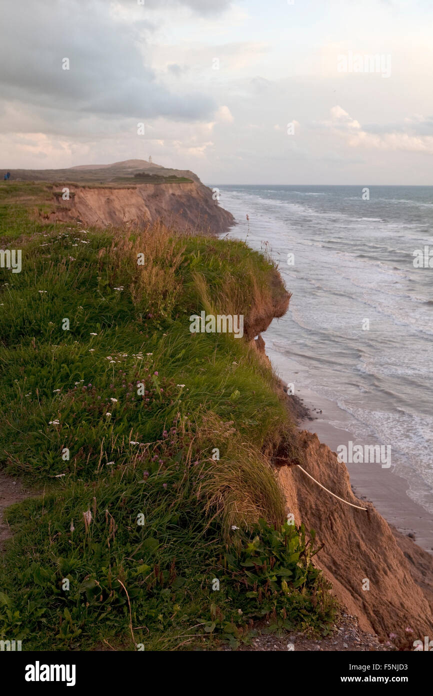 A cliff built up over time of sand is dangerously eroding. Precarious ...