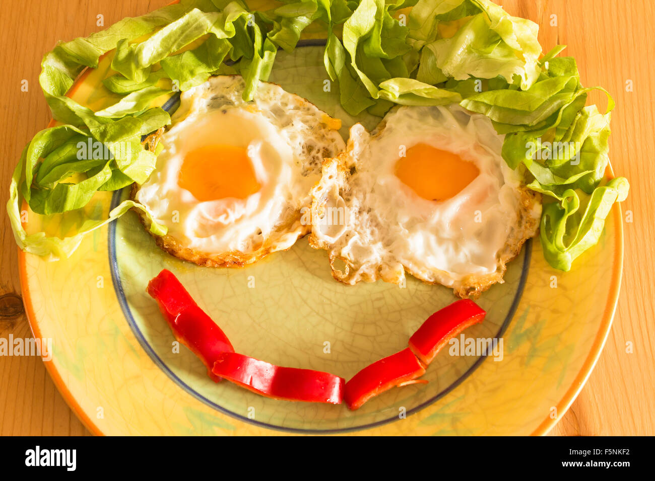 Smiley breakfast of eggs and lettuce Stock Photo - Alamy