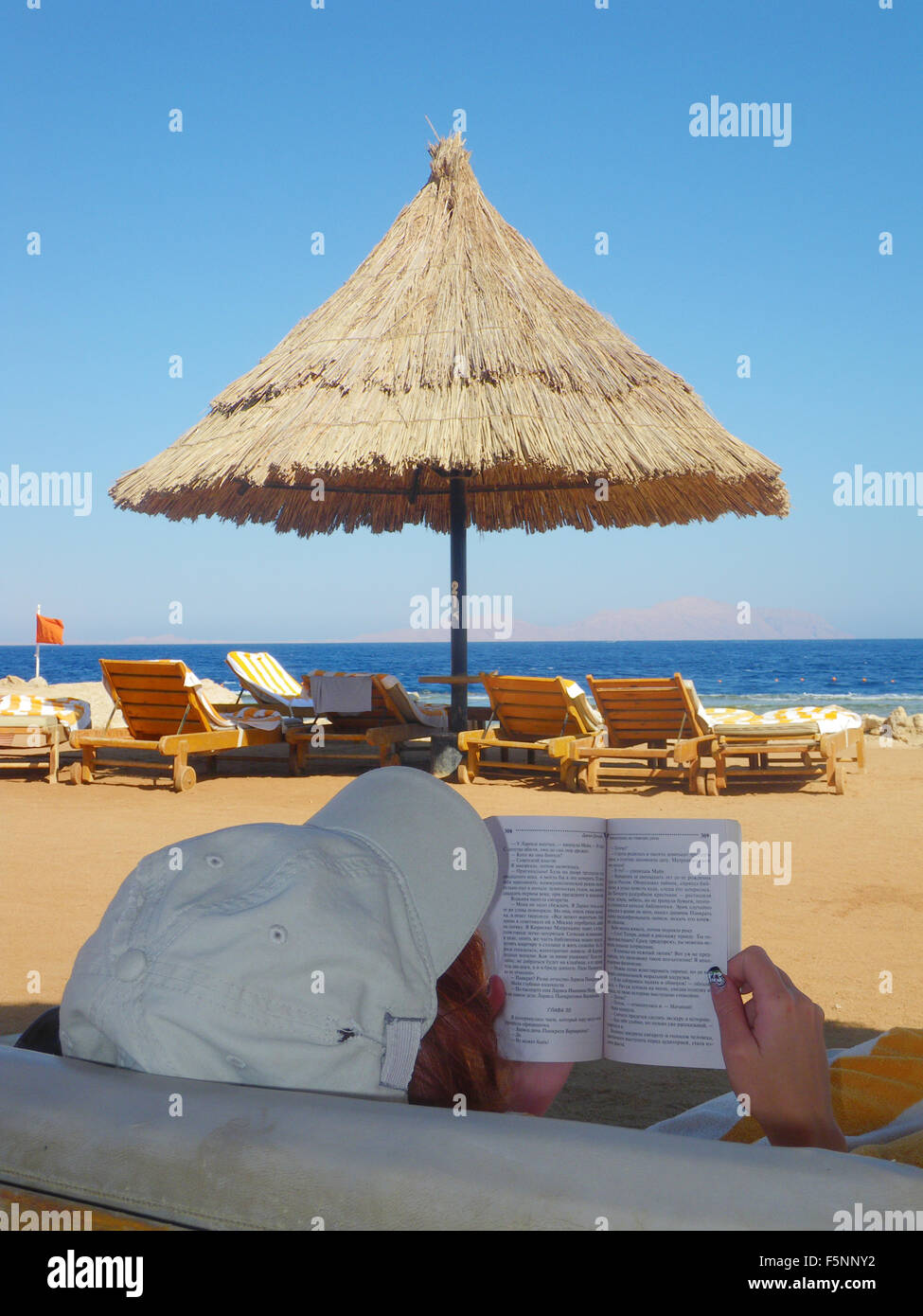 Woman reading on the beach Stock Photo - Alamy