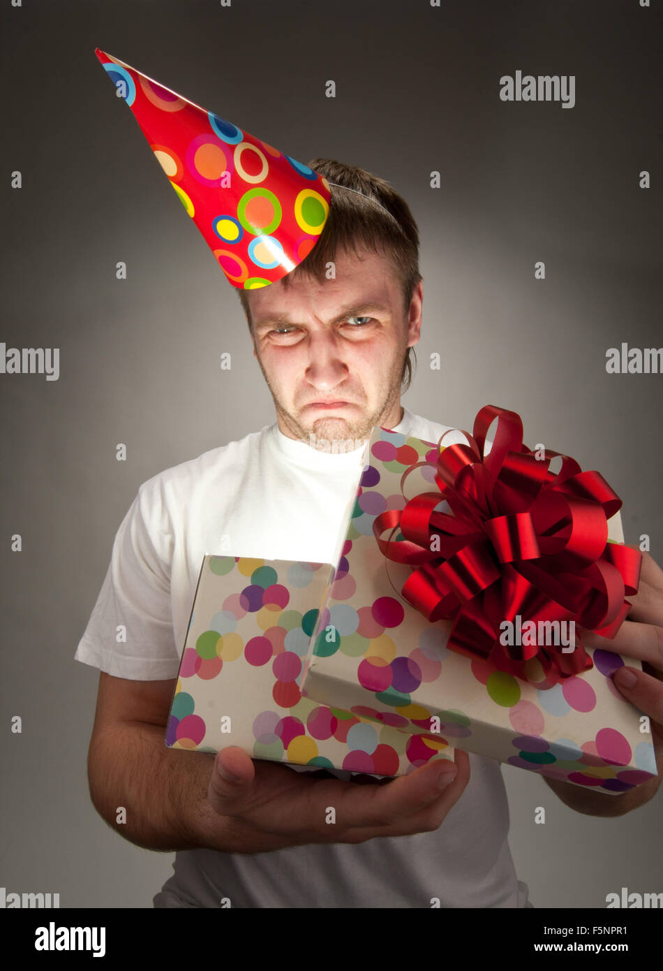 Sad birthday man opening big gift box Stock Photo - Alamy