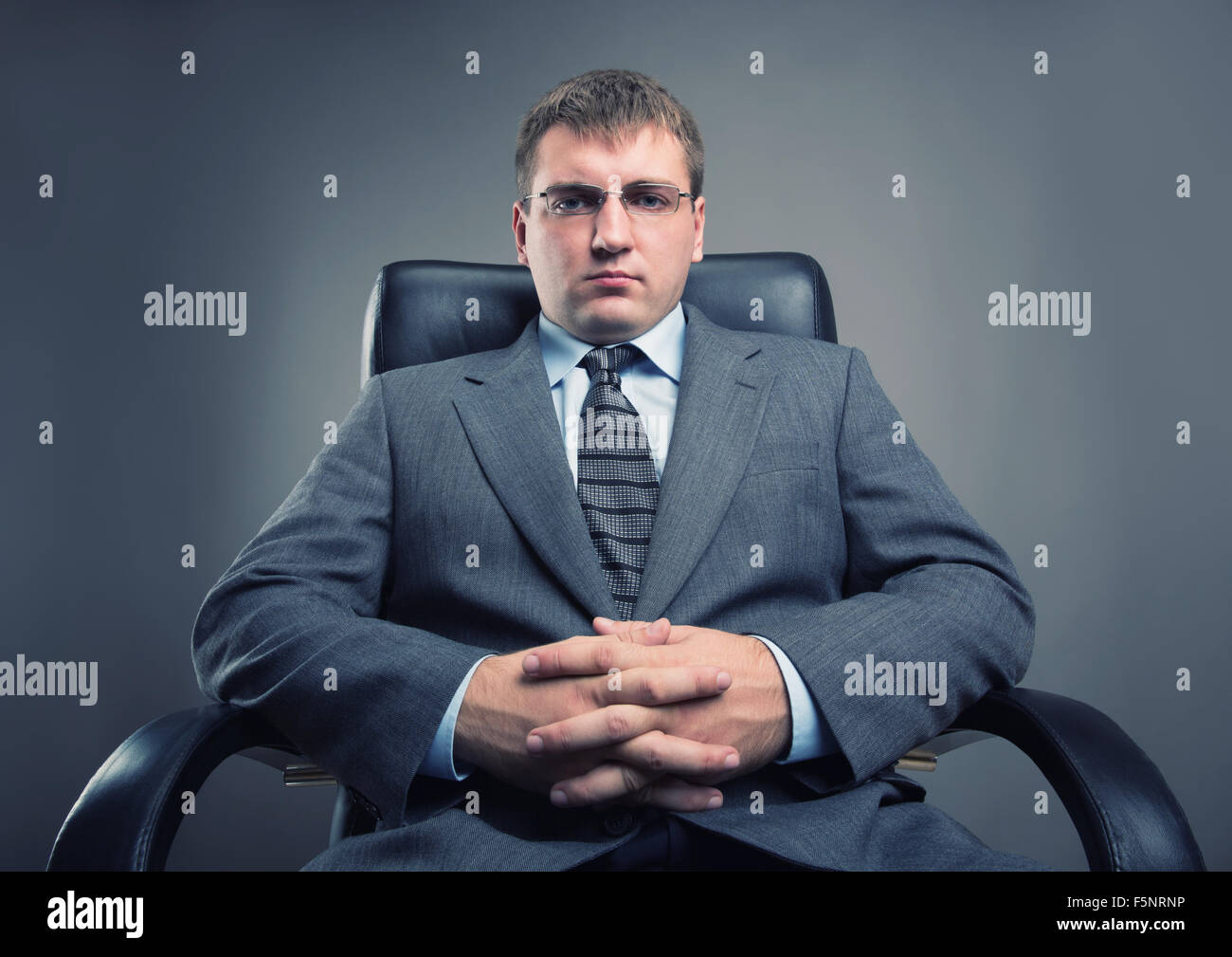 Young man in a suit looking straight ahead Stock Photo - Alamy