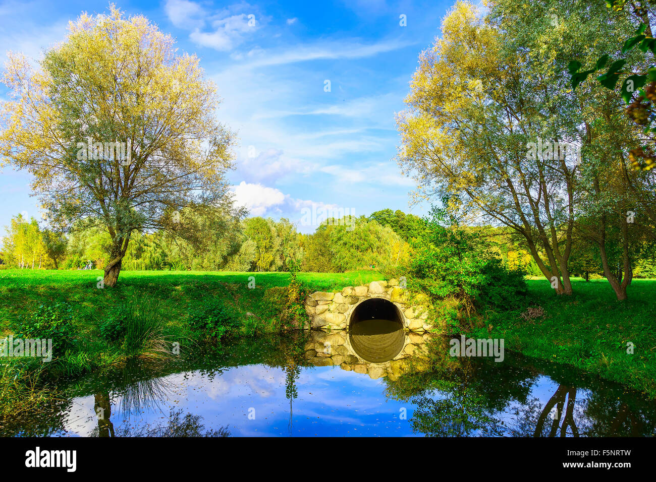 Stone Arch over Pond in Autumn Park at Sunny Day Stock Photo - Alamy