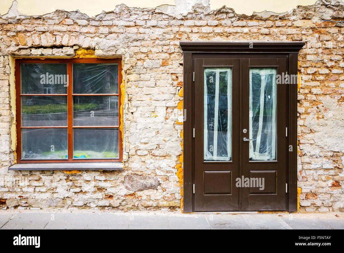 Old weathered street wall with a window and door Stock Photo - Alamy