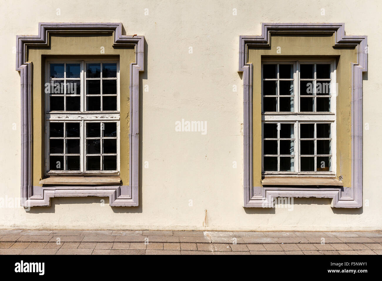 Yellow wall with two old unusual form windows Stock Photo - Alamy