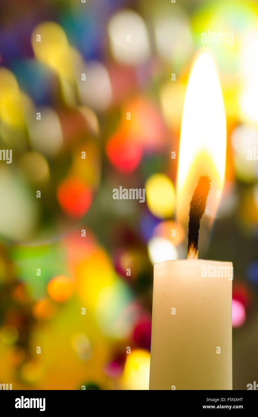 Christmas candle over colorful lights background Stock Photo - Alamy