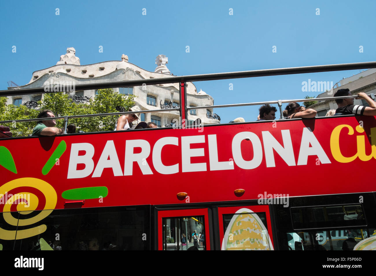 Tour bus passing La Pedrera designed by architect Antoni Gaudi ...