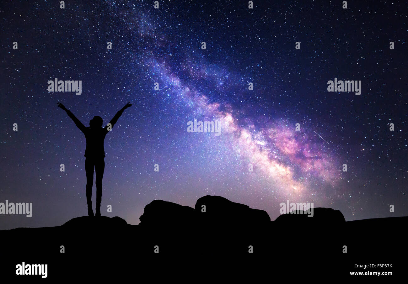 Milky Way. Night sky with stars and silhouette of a woman practicing ...