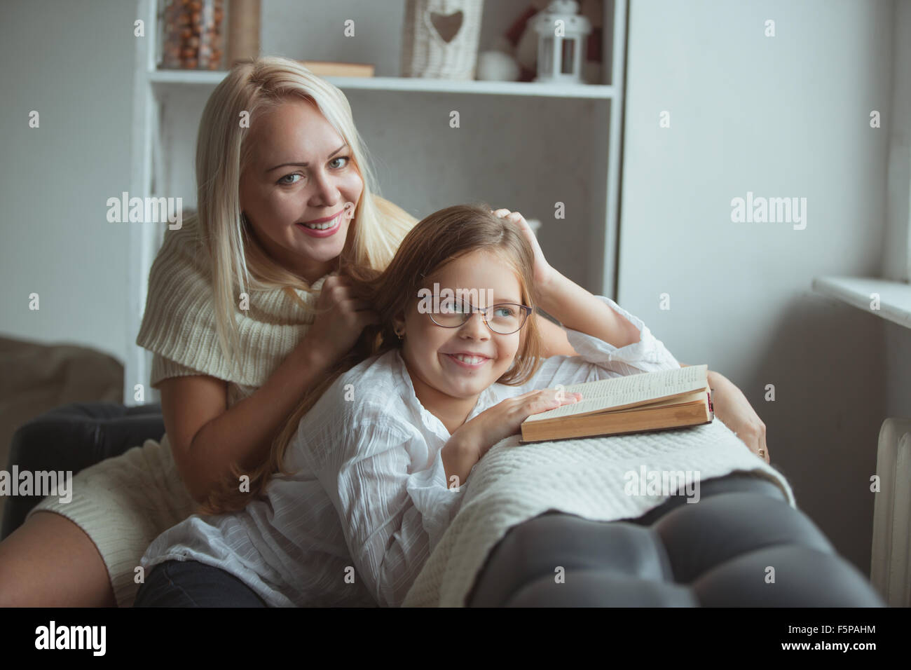 Mother with daughter reading book Stock Photo - Alamy