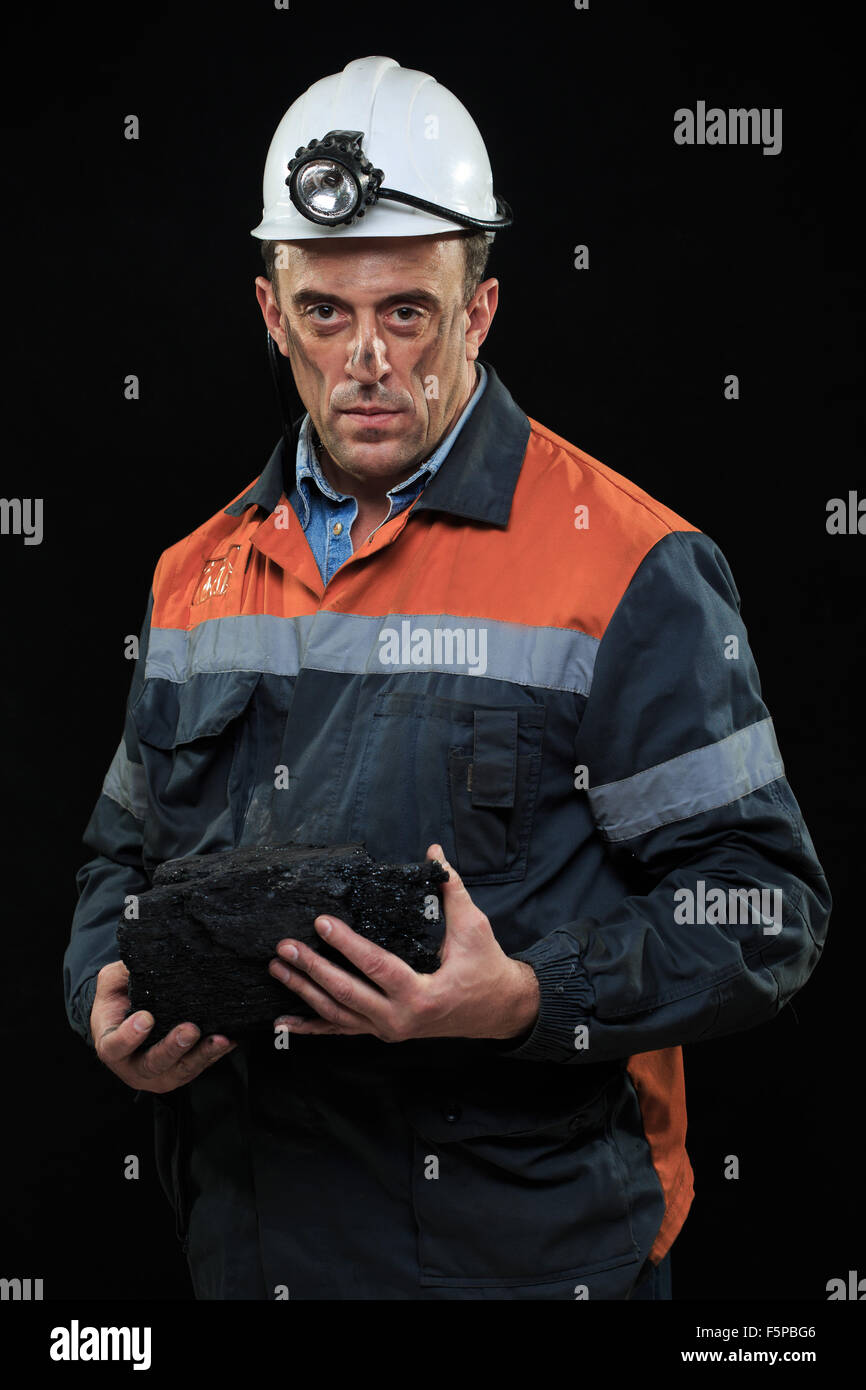 Coal miner showing lump of coal with thumbs up against a dark Stock ...