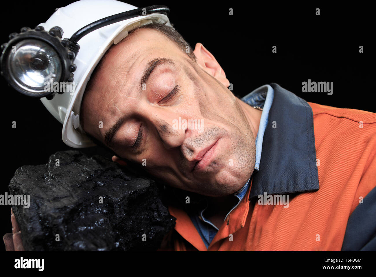 Coal miner showing lump of coal with thumbs up against a dark Stock ...