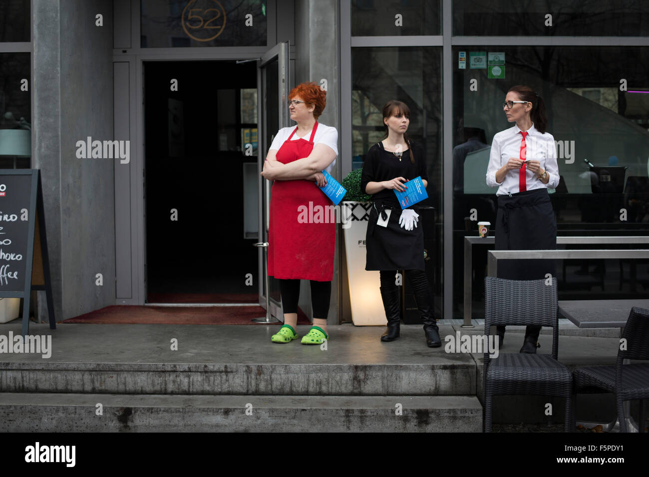 Three waitresses watching crowds marching through the streets of Berlin ...