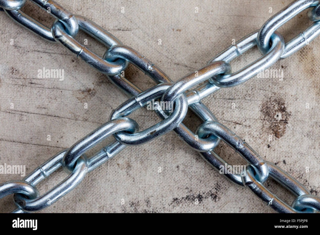 Two metal chains crossed on old canvas background Stock Photo - Alamy
