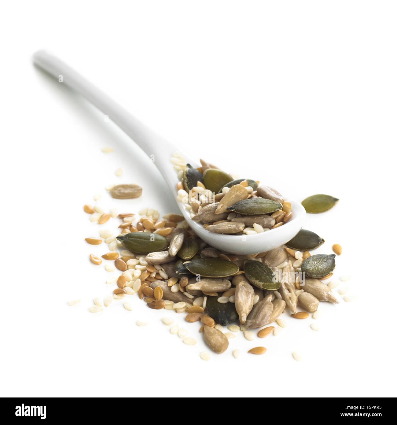 Various seeds and a spoon against a white background Stock Photo - Alamy