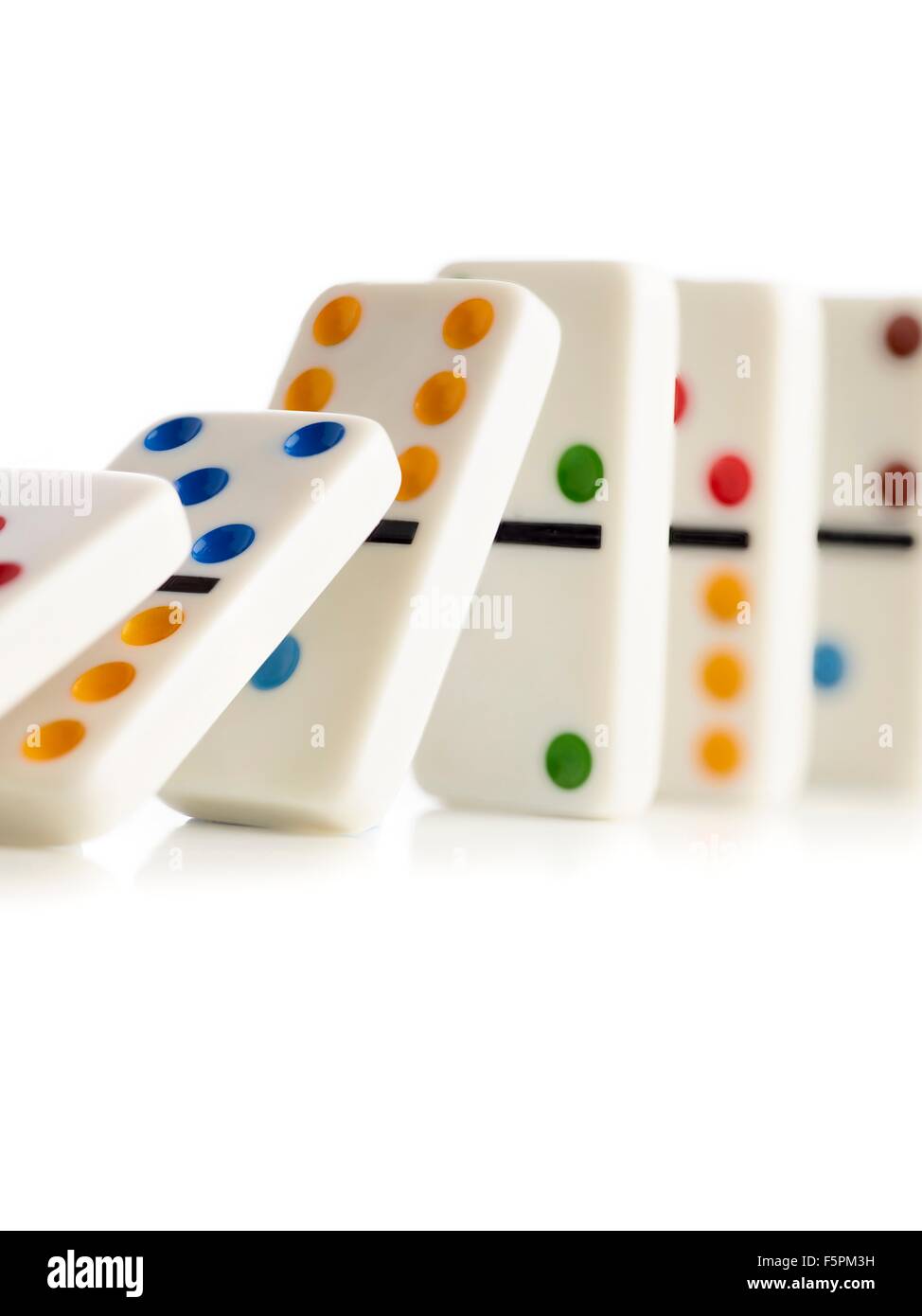 Colourful dominoes falling down against a white background Stock Photo ...