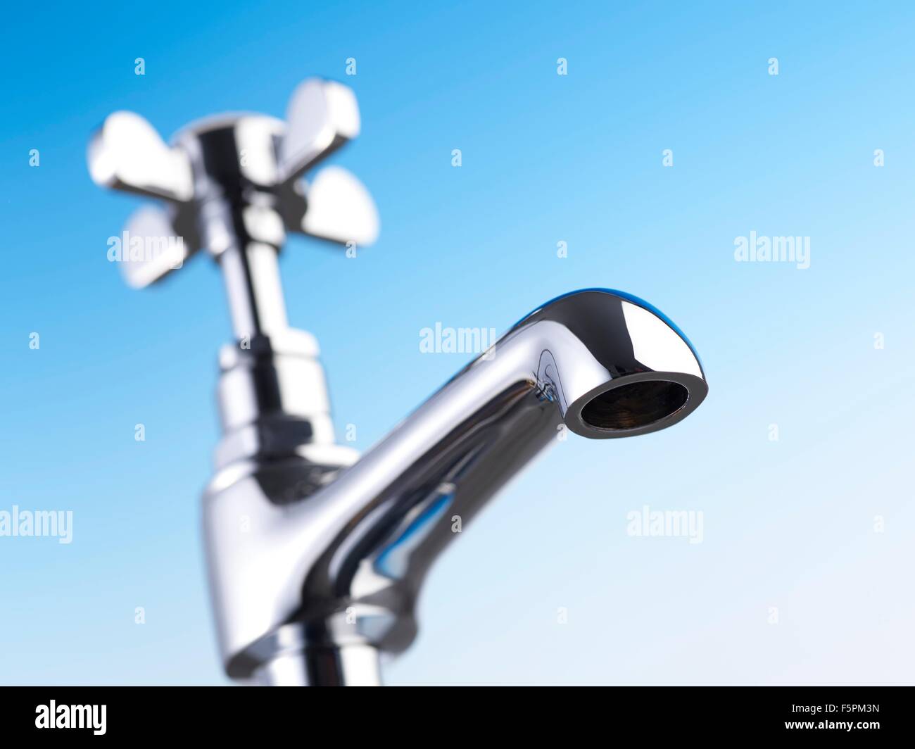 Metal tap against a blue background Stock Photo - Alamy